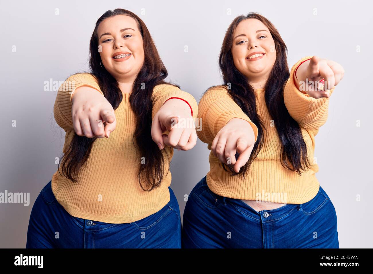 Young plus size twins wearing casual clothes pointing to you and the ...