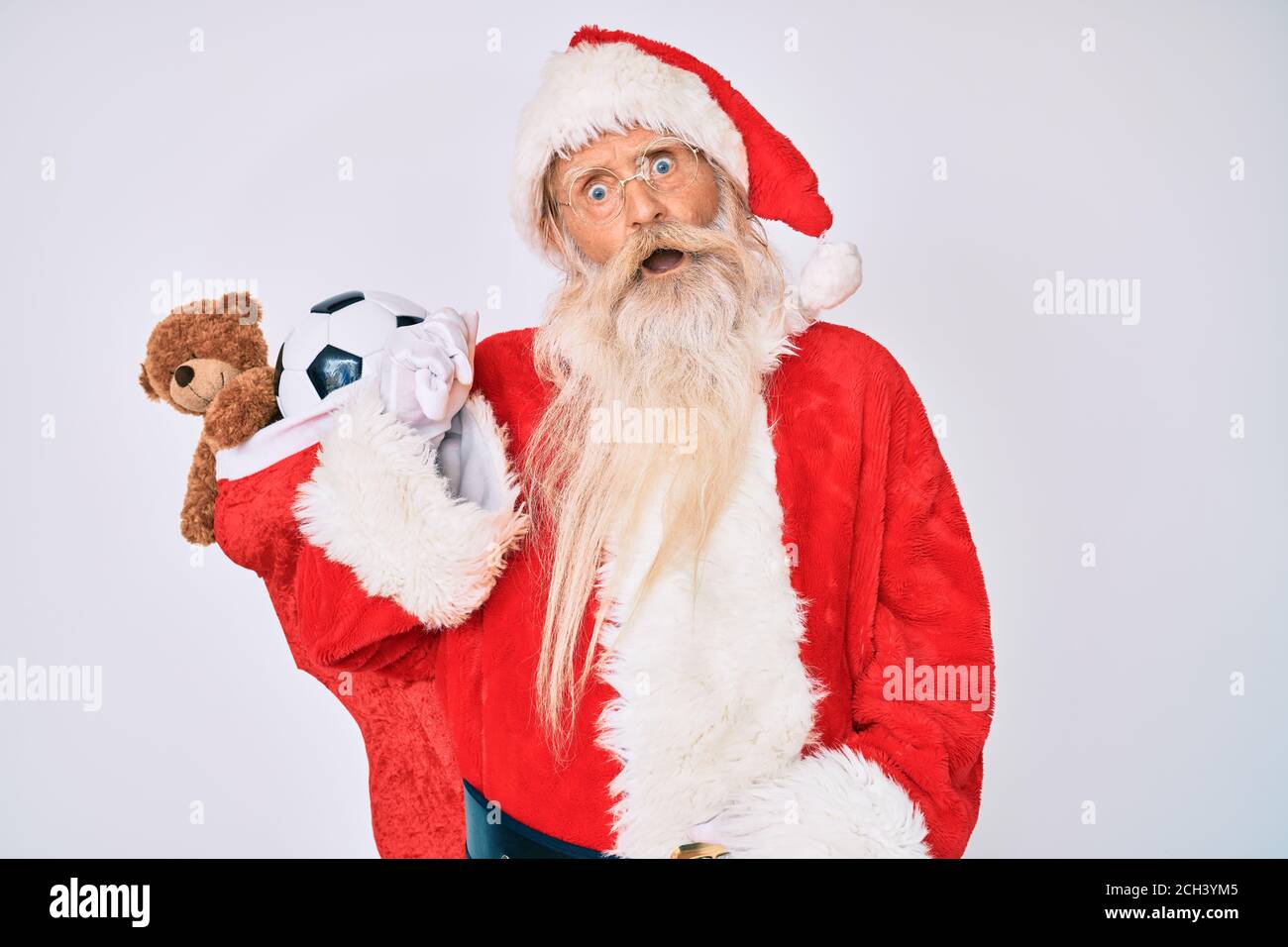 Old senior man with grey hair and long beard wearing santa claus ...