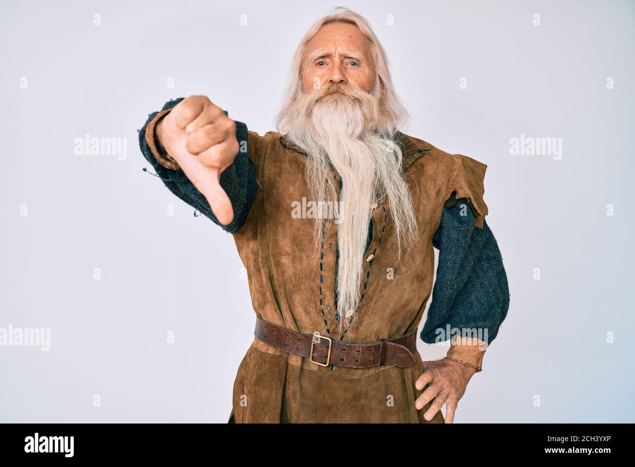 Old senior man with grey hair and long beard wearing viking traditional ...