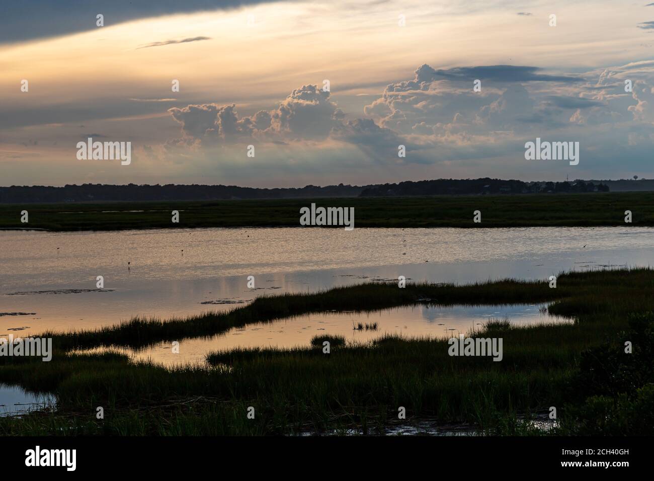 Colorful rainbow clouds glowing after a storm passes above the marshes ...
