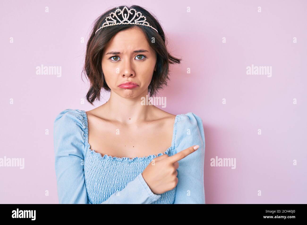Young beautiful girl wearing princess crown depressed and worry for ...