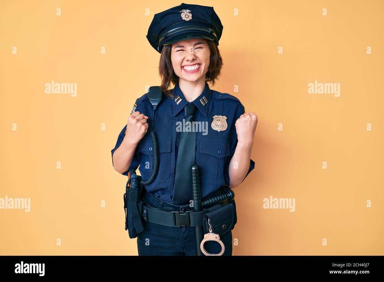 Young beautiful woman wearing police uniform excited for success with ...