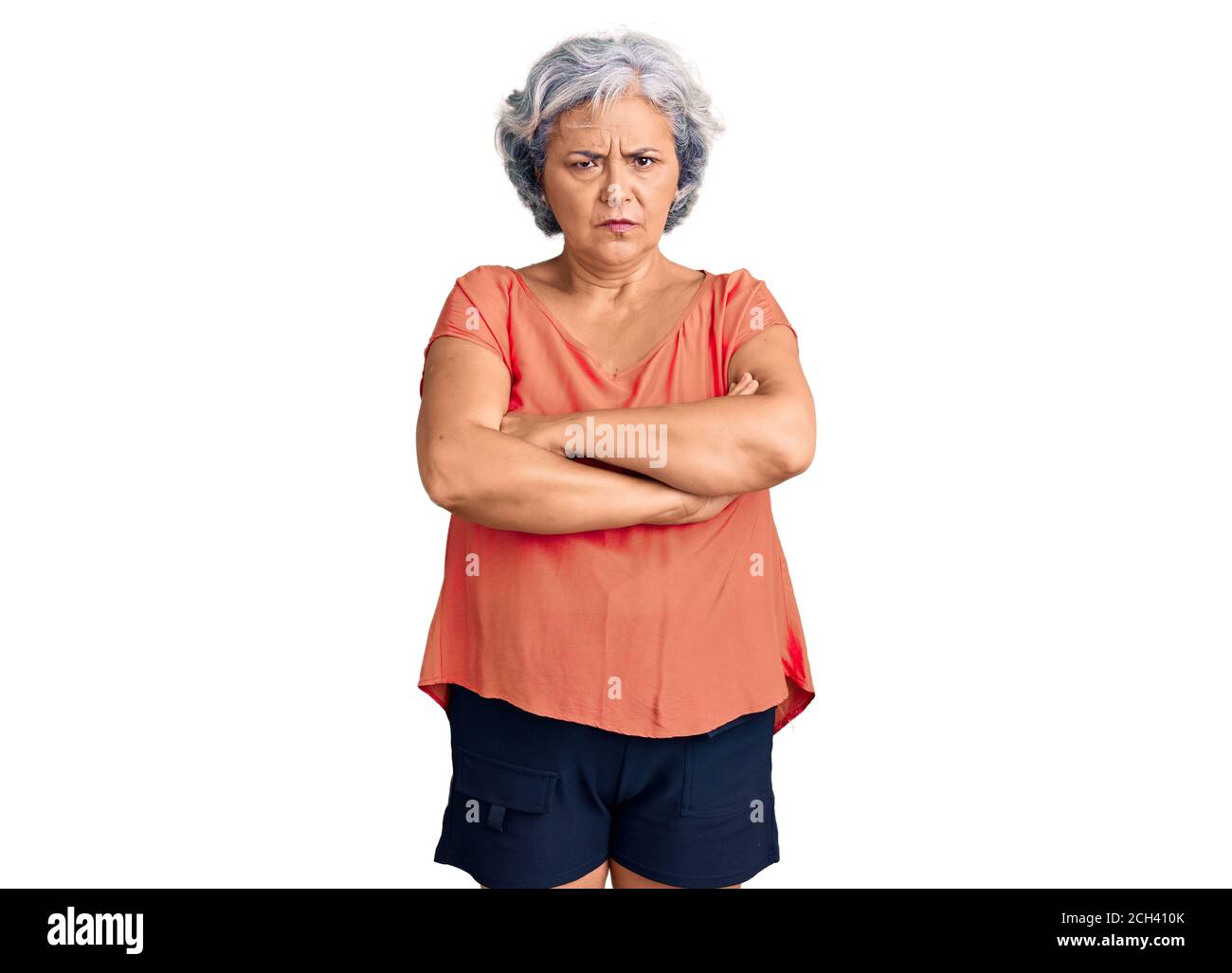 Senior woman with gray hair wearing orange tshirt skeptic and nervous ...