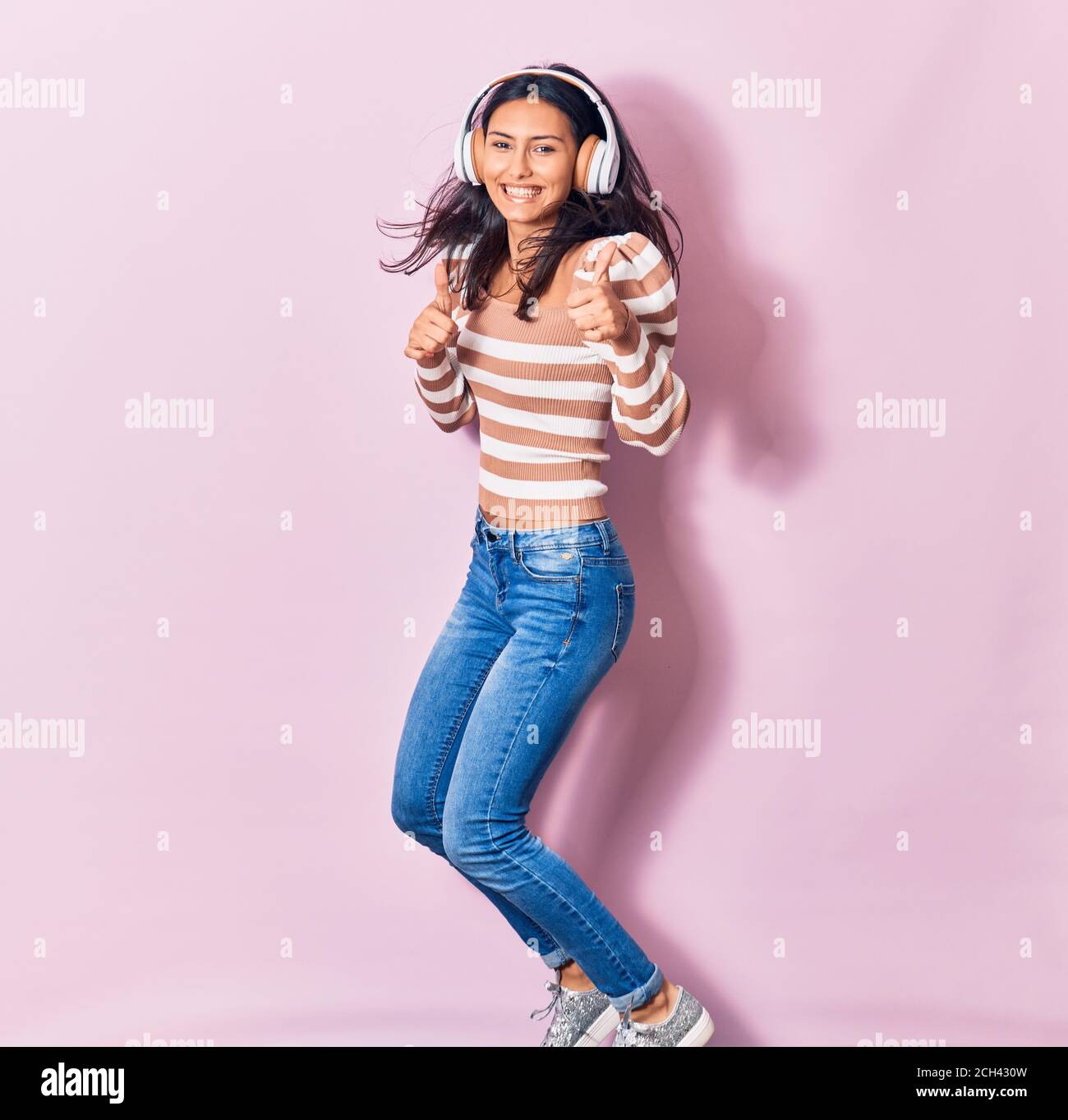 Young beautiful hispanic woman smiling happy. Jumping with smile on ...