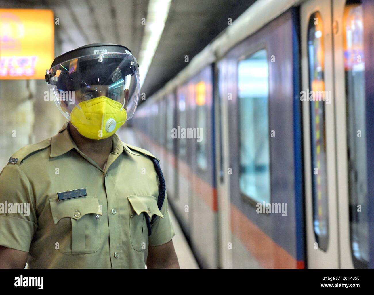 A police officer wearing a face Shield stands on guard at a Metro ...