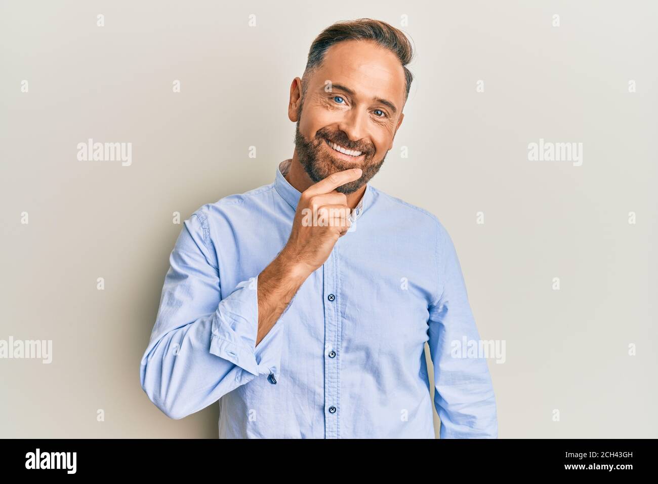 Handsome middle age man wearing business clothes smiling looking ...