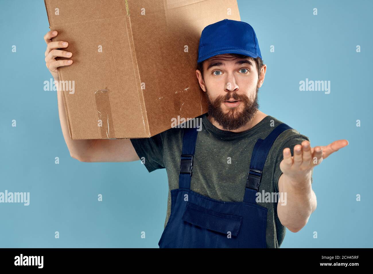 A man in working uniform with boxes in the hands of a carriage delivery ...