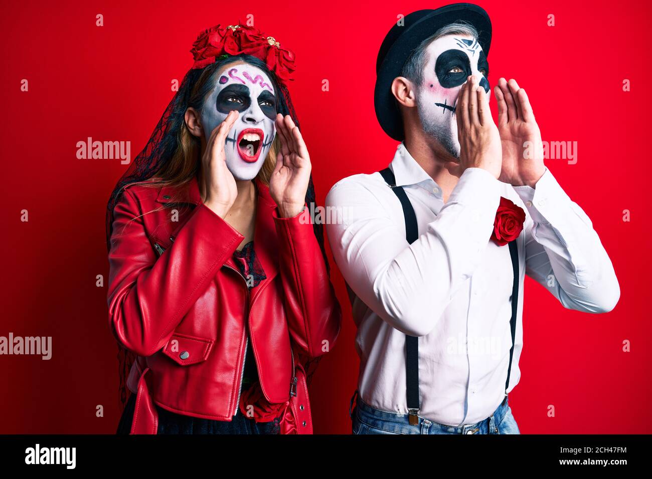 Couple wearing day of the dead costume over red shouting angry out loud ...