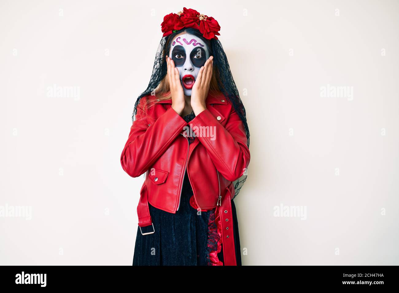 Woman wearing day of the dead costume over white afraid and shocked ...