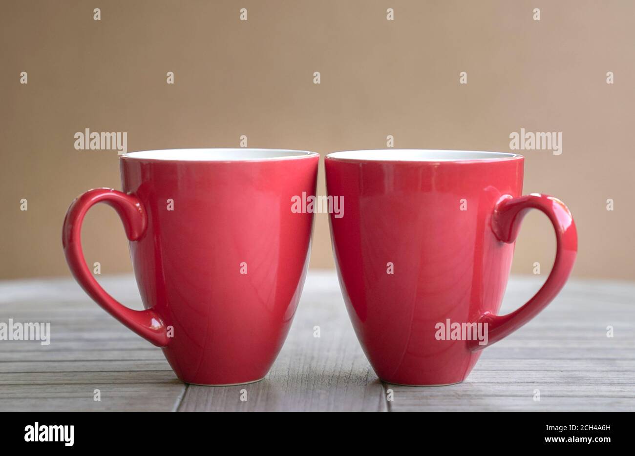 Two red cups on wood table. Isolated Stock Photo - Alamy