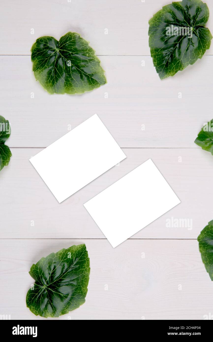 Business card mockup with copy space and leaf on wooden table, name ...