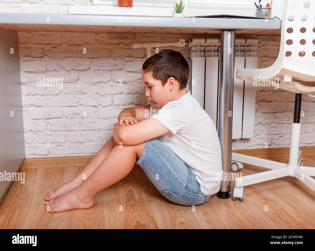 Upset lonely bullied little caucasian kid boy hugging his knee Stock ...