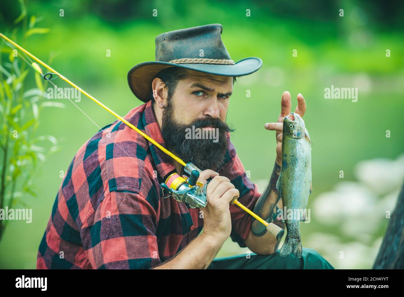 Fisherman with rod and fish. Keep calm and fish on.Fishing on the lake ...