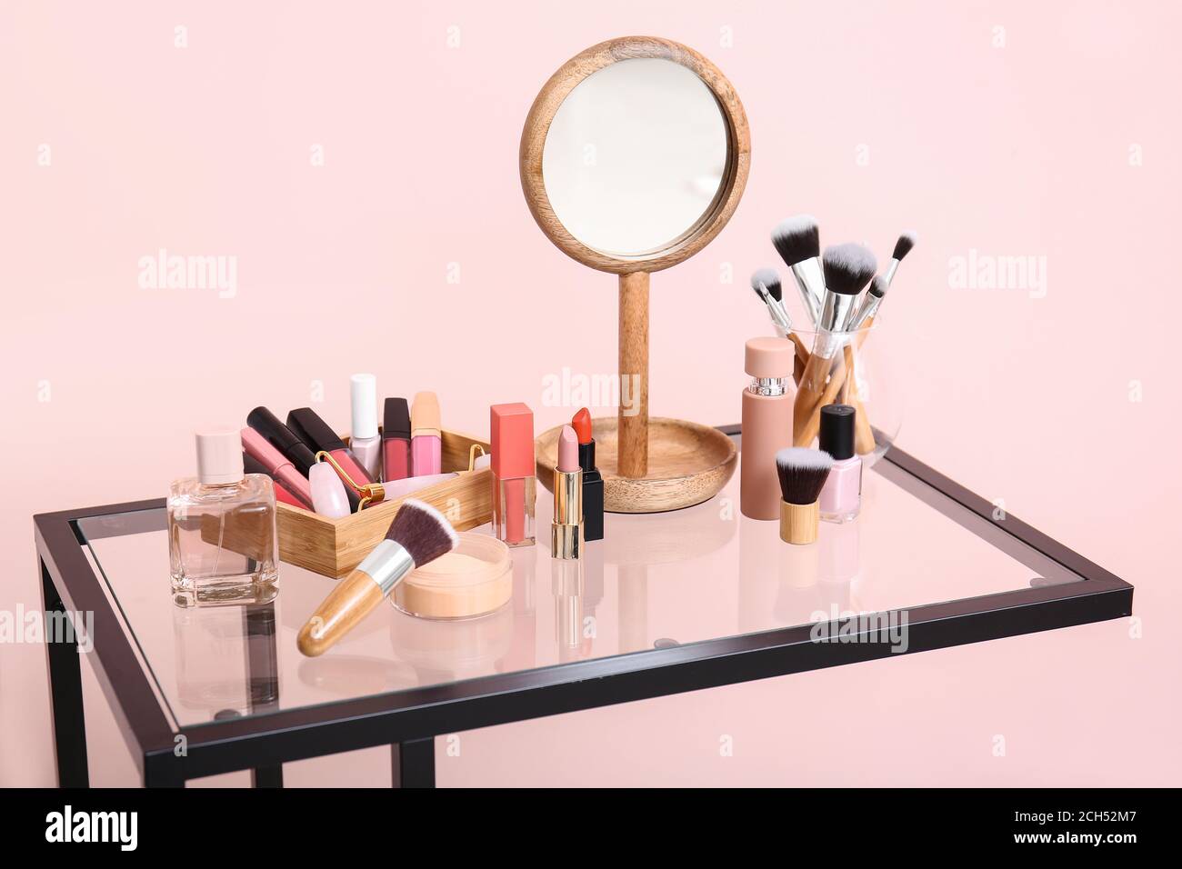 Set of makeup cosmetics with brushes and mirror on table Stock Photo ...