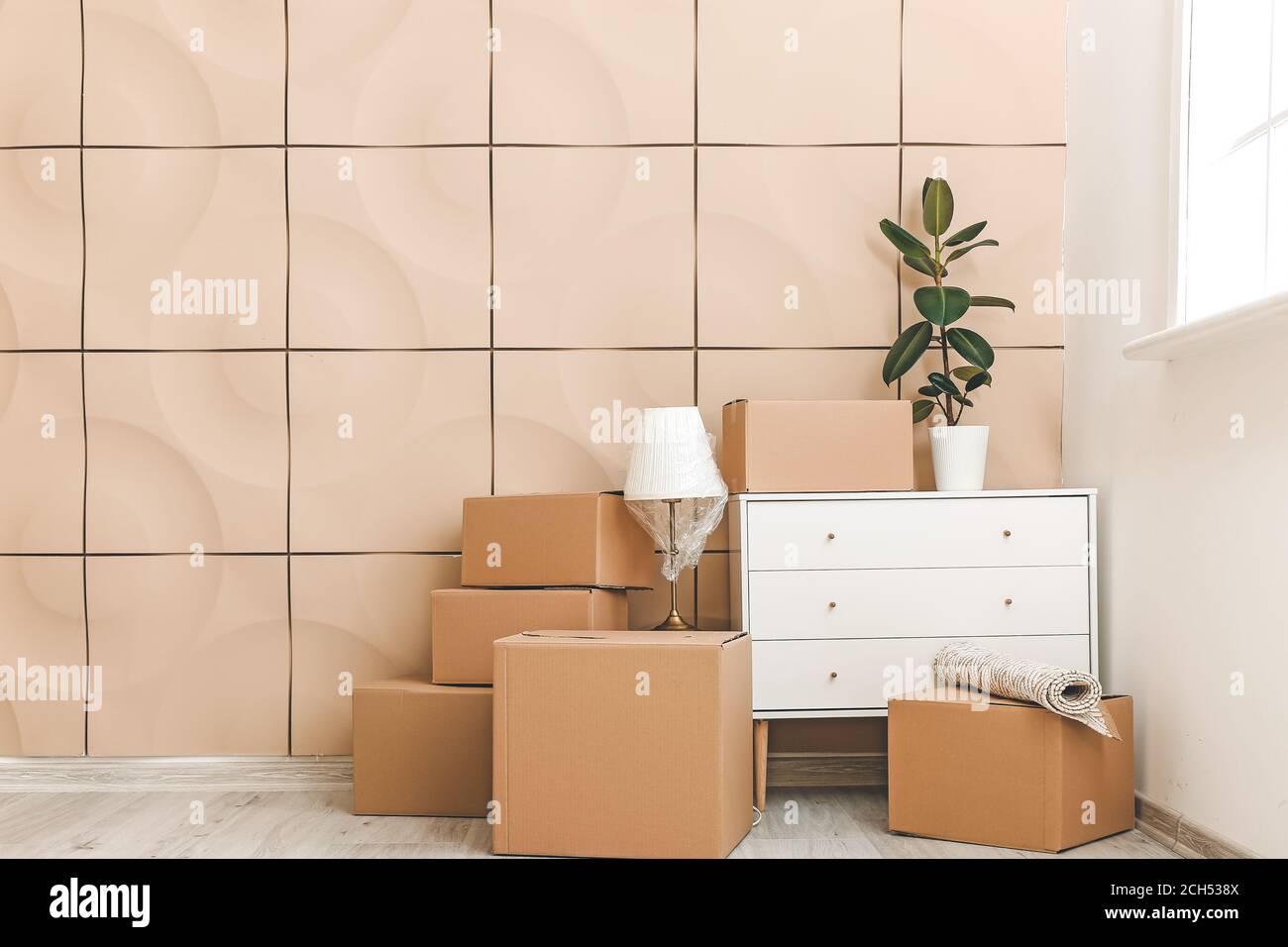 Cardboard boxes with belongings and chest of drawers in new flat on ...