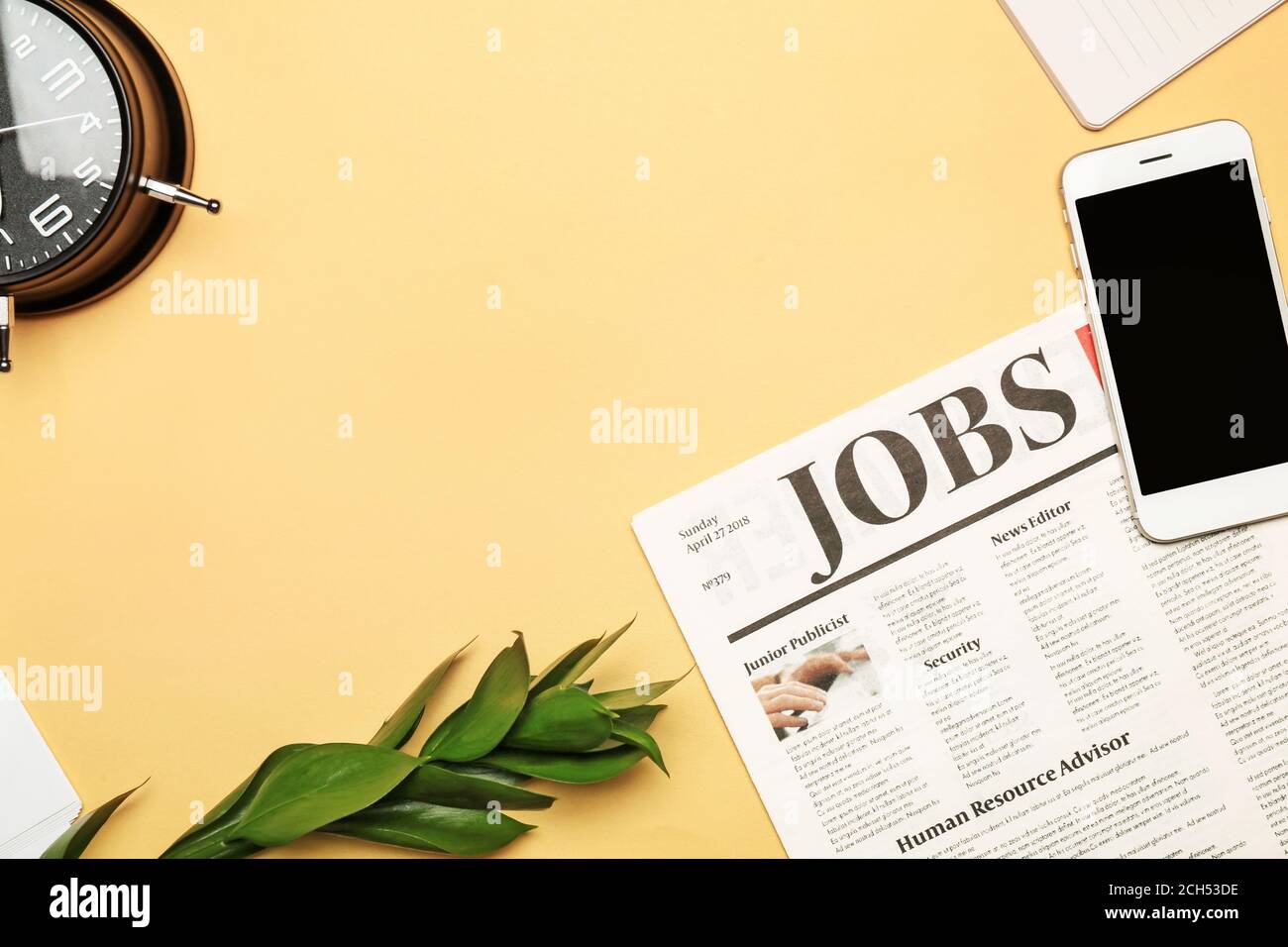 Mobile phone with newspaper and alarm clock on color background Stock ...