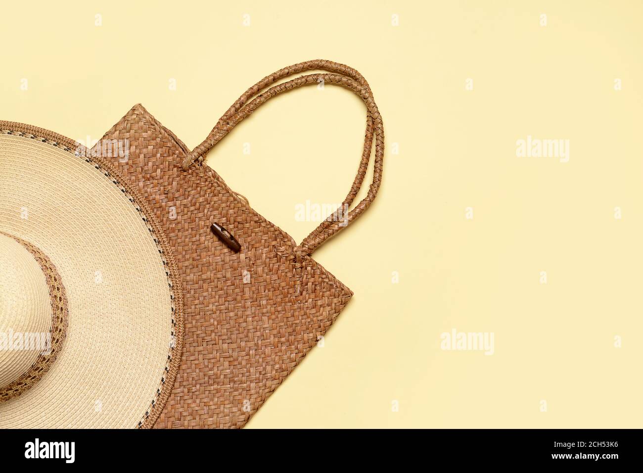 Straw hat and bag on color background Stock Photo - Alamy