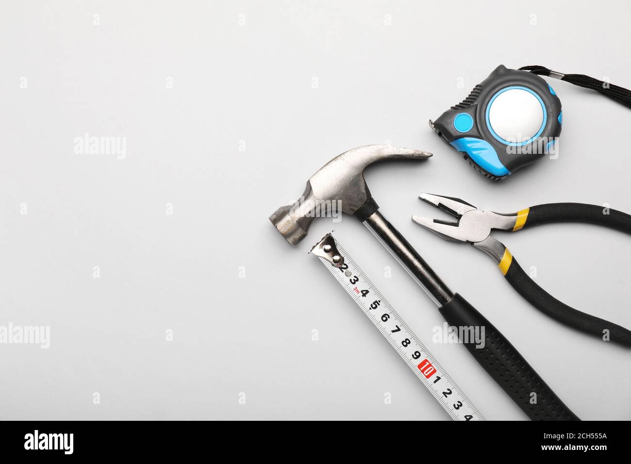 Measuring tape with builder's supplies on white background Stock Photo ...