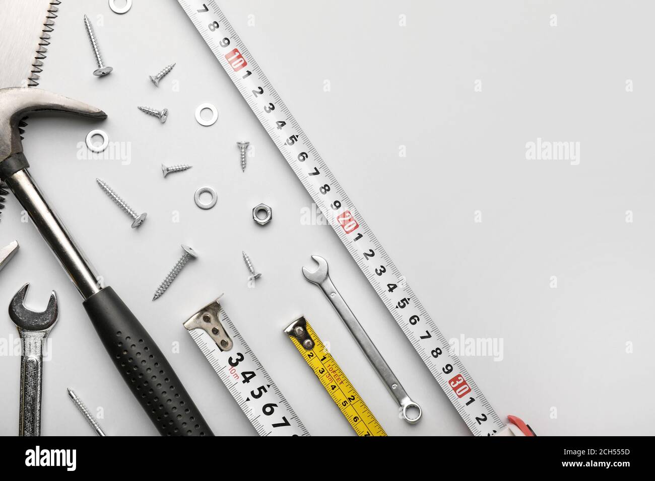 Measuring tapes with builder's supplies on white background Stock Photo ...
