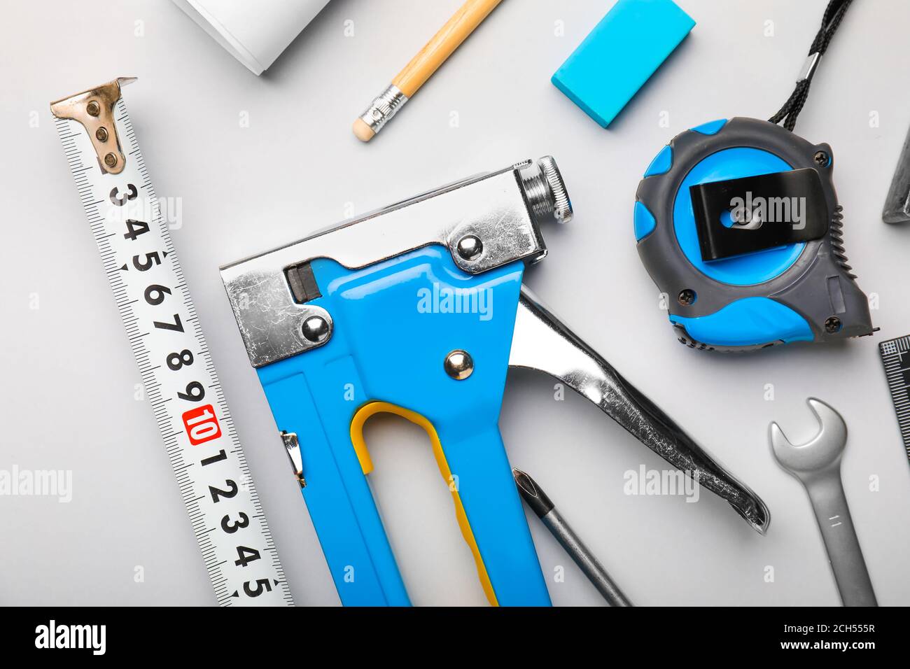Measuring tape with builder's supplies on white background Stock Photo ...