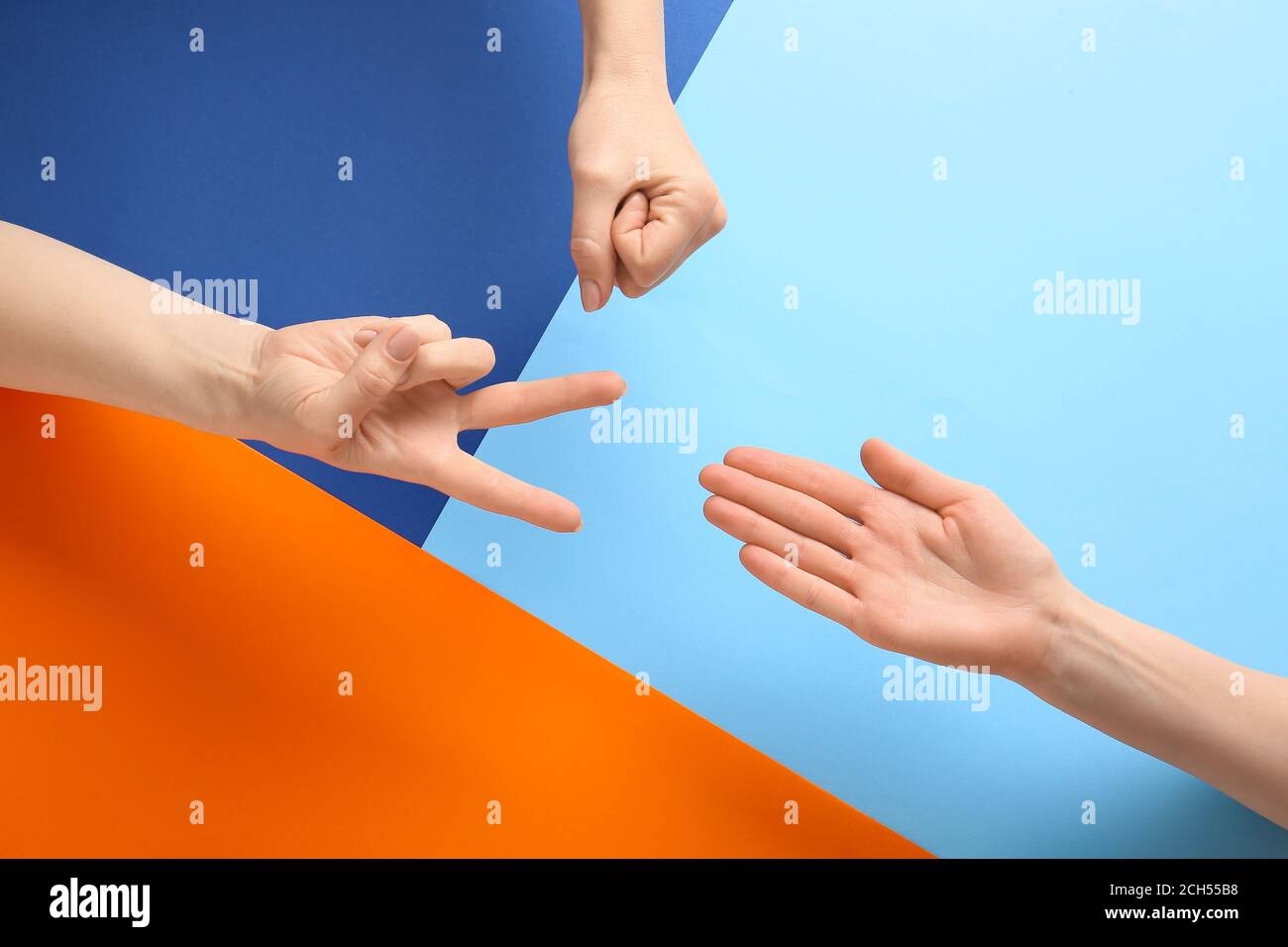 People playing roshambo game on color background Stock Photo - Alamy