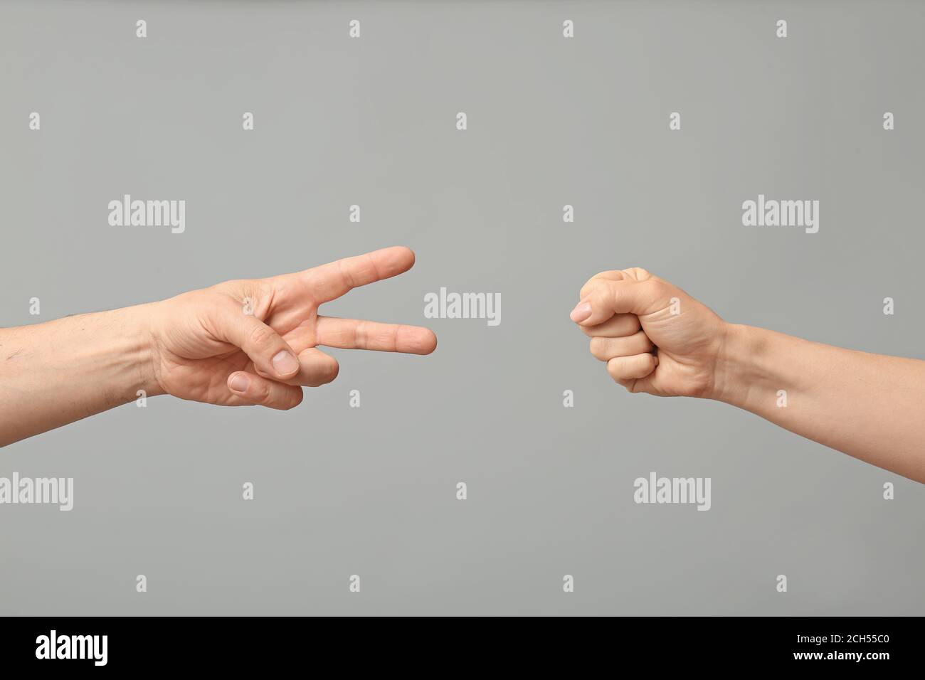 People playing roshambo game on grey background Stock Photo - Alamy