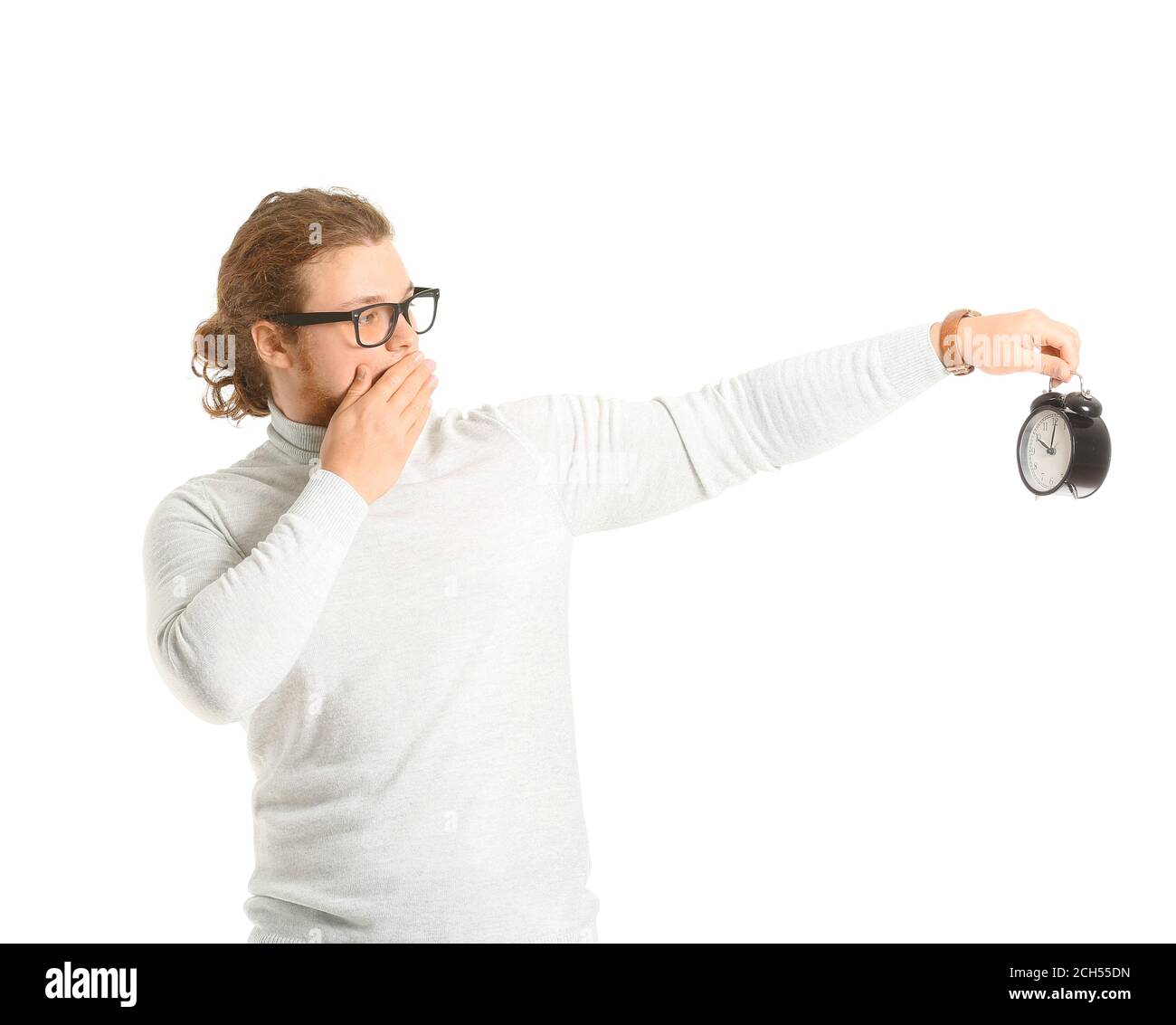 Shocked man with alarm clock on white background Stock Photo - Alamy