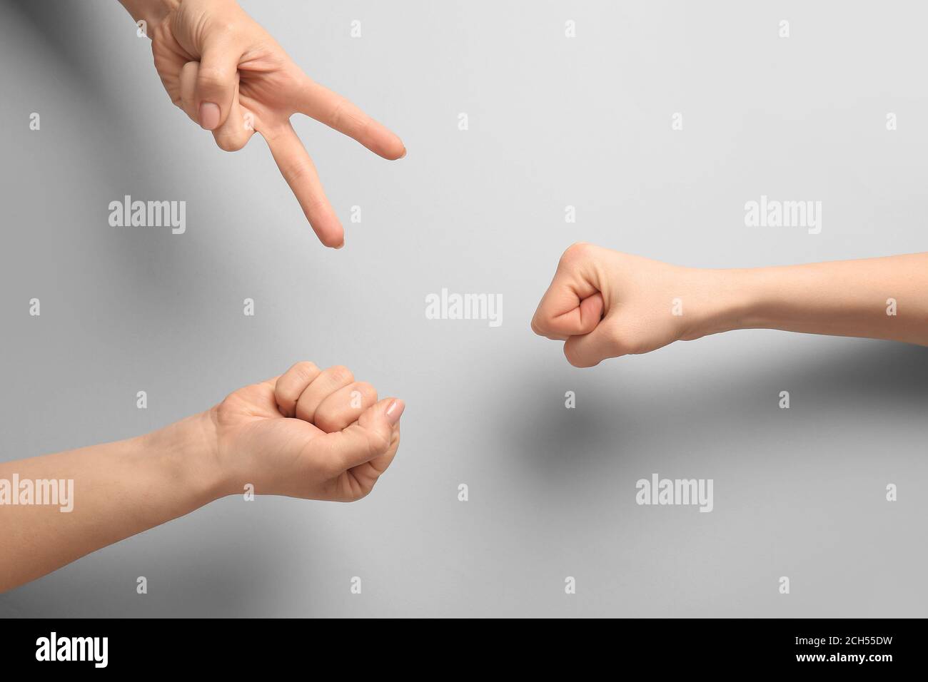 People playing roshambo game on grey background Stock Photo - Alamy