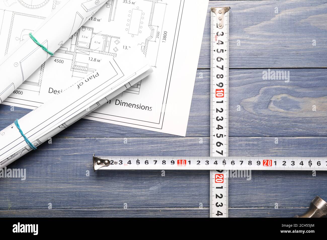 Measuring tapes with blueprints on table Stock Photo - Alamy