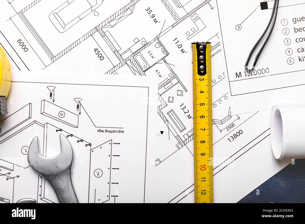 Measuring tape with blueprints on table Stock Photo - Alamy