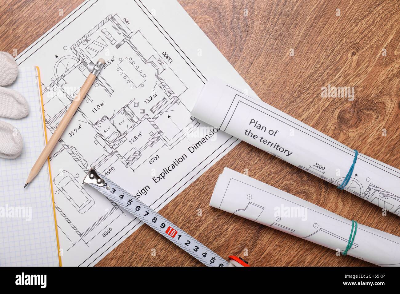 Measuring tape with blueprints on wooden background Stock Photo - Alamy