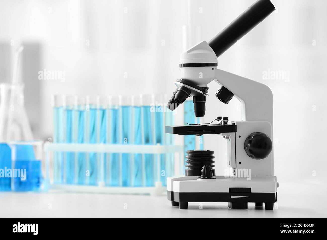 Modern microscope and glassware on table in laboratory Stock Photo - Alamy