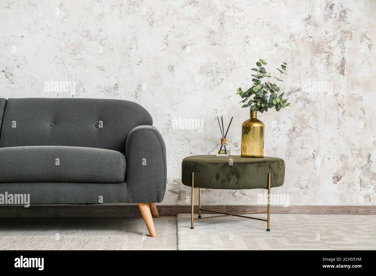 Stylish interior of living room with pouf and sofa Stock Photo - Alamy