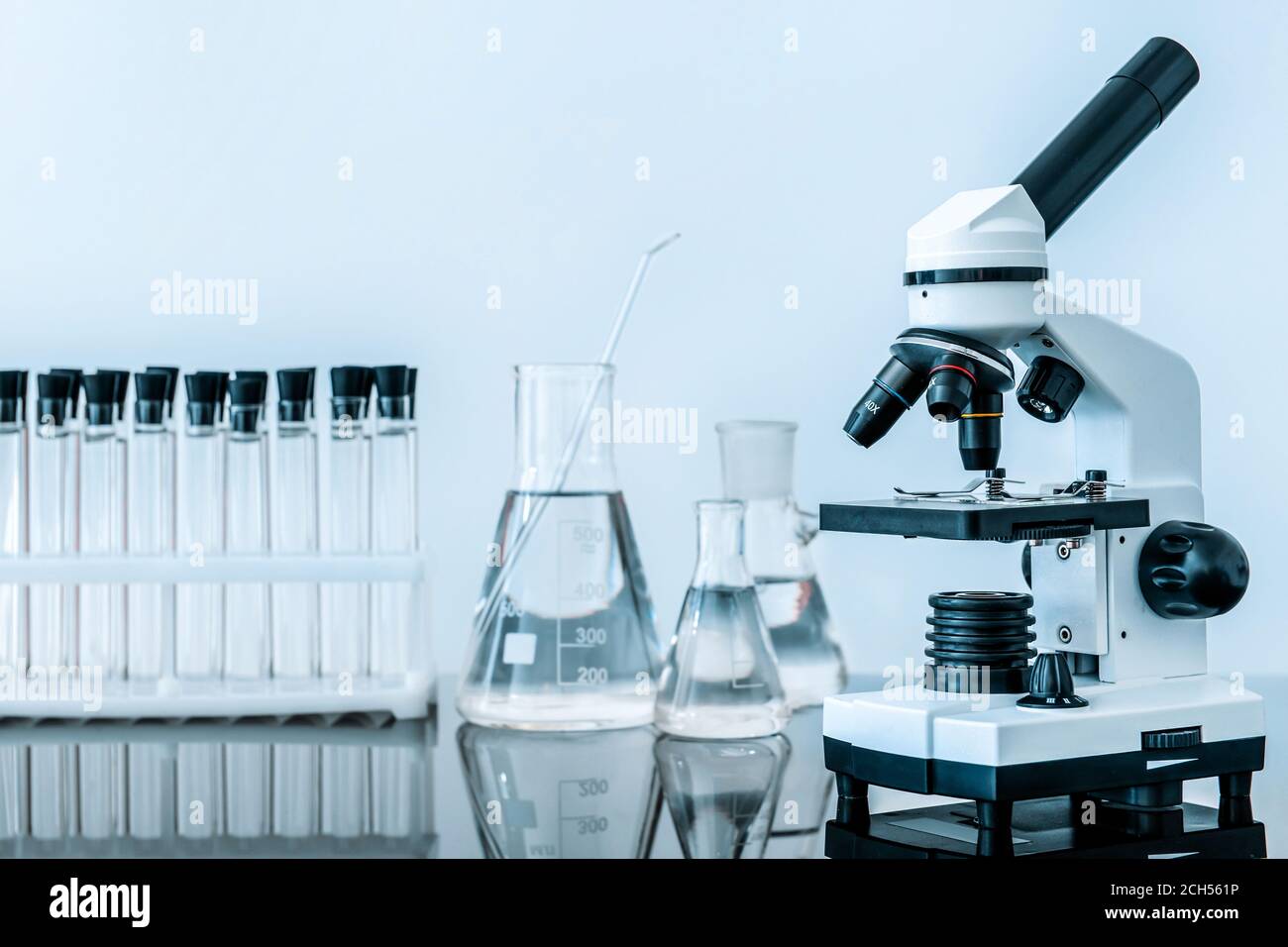 Microscope and glassware on table in laboratory Stock Photo - Alamy