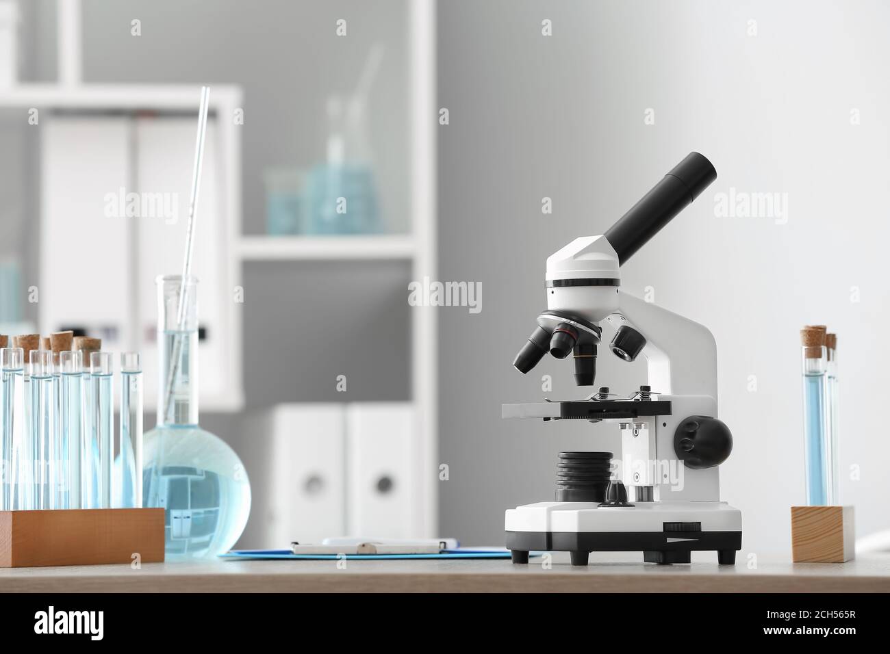 Microscope and glassware on table in laboratory Stock Photo - Alamy