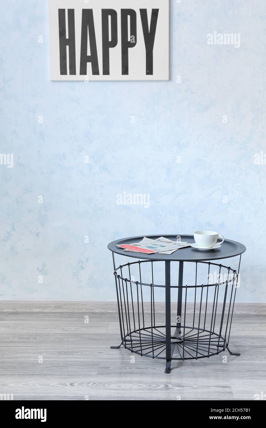 Stylish table near light wall Stock Photo - Alamy