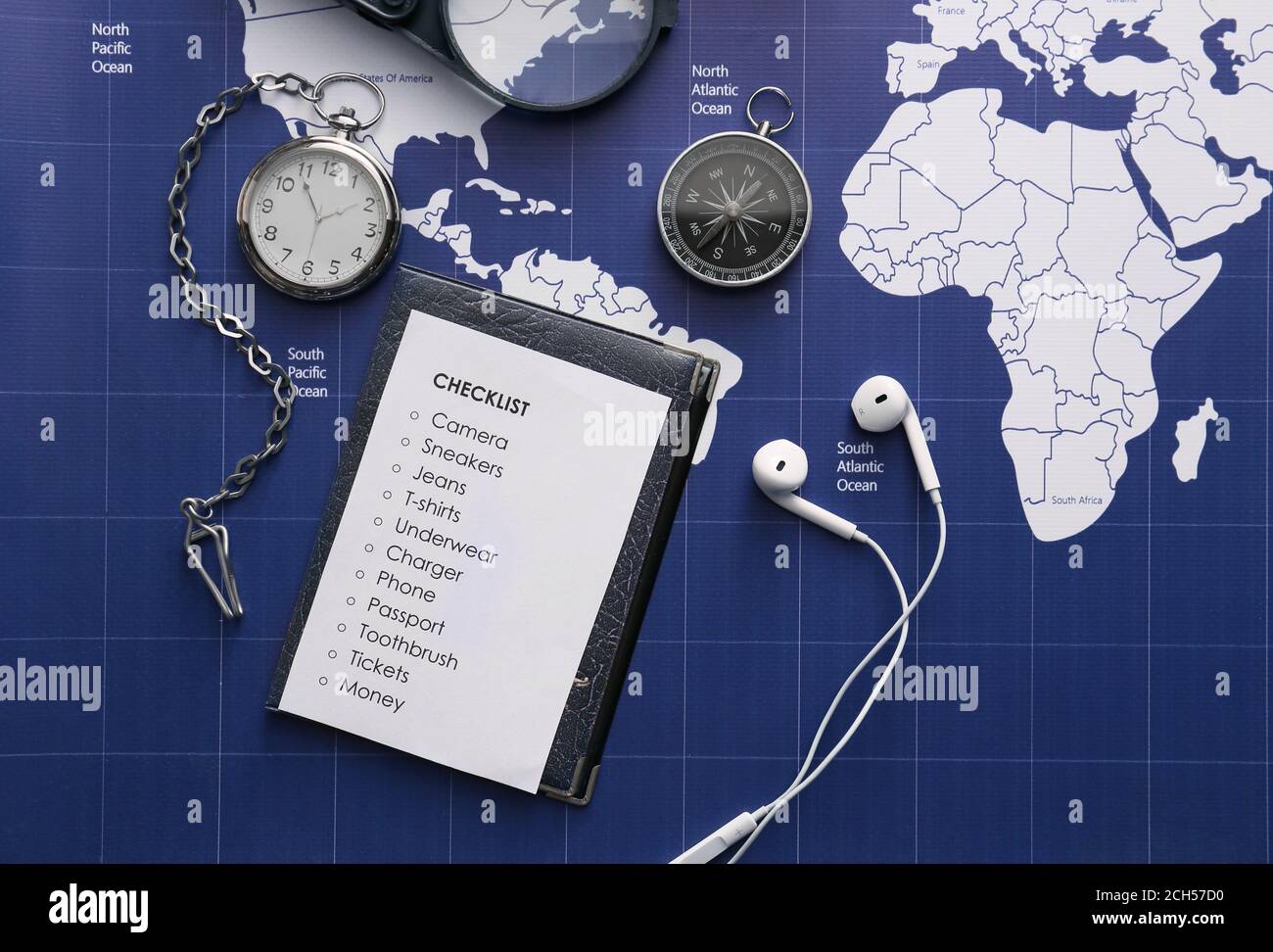 Check-list of things to pack for travel on world map Stock Photo - Alamy