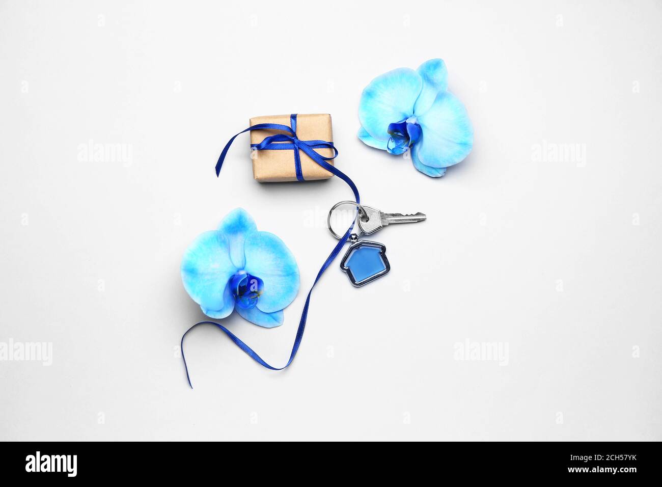 Gift box with key from house on white background Stock Photo - Alamy