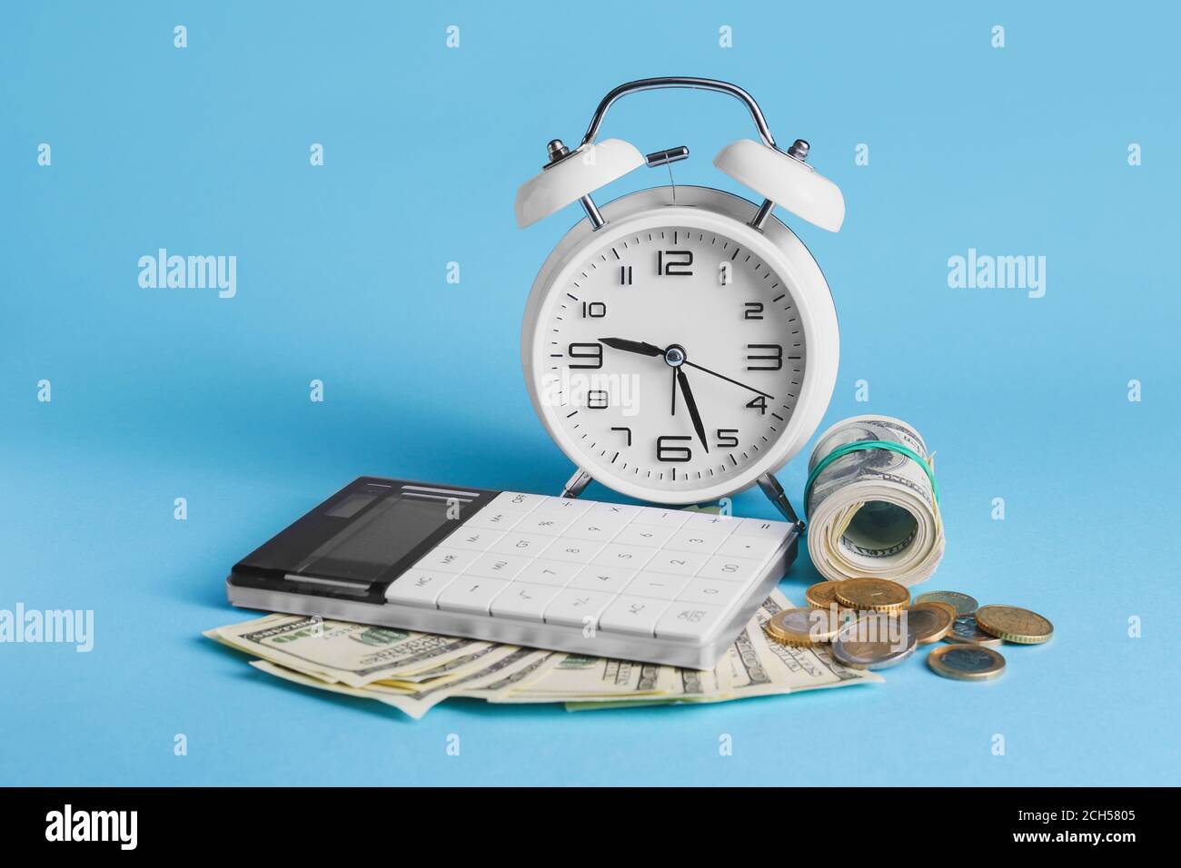 Alarm clock with calculator and money on color background Stock Photo ...