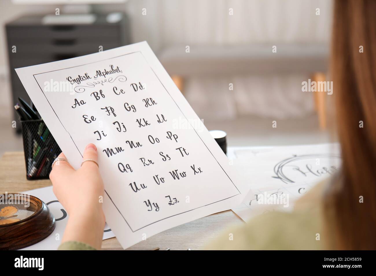 Female calligraphist working in office Stock Photo - Alamy