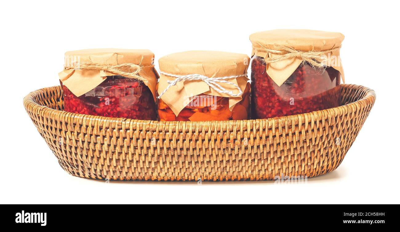 Wicker basket with jars of jam on white background Stock Photo - Alamy