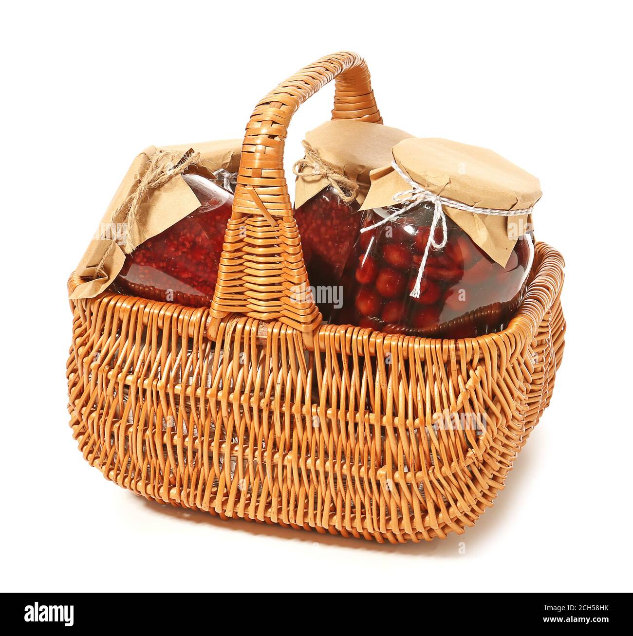 Wicker basket with jars of jam on white background Stock Photo - Alamy