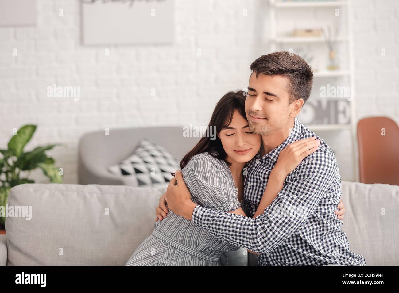 Happy couple hugging after quarrel at home Stock Photo - Alamy