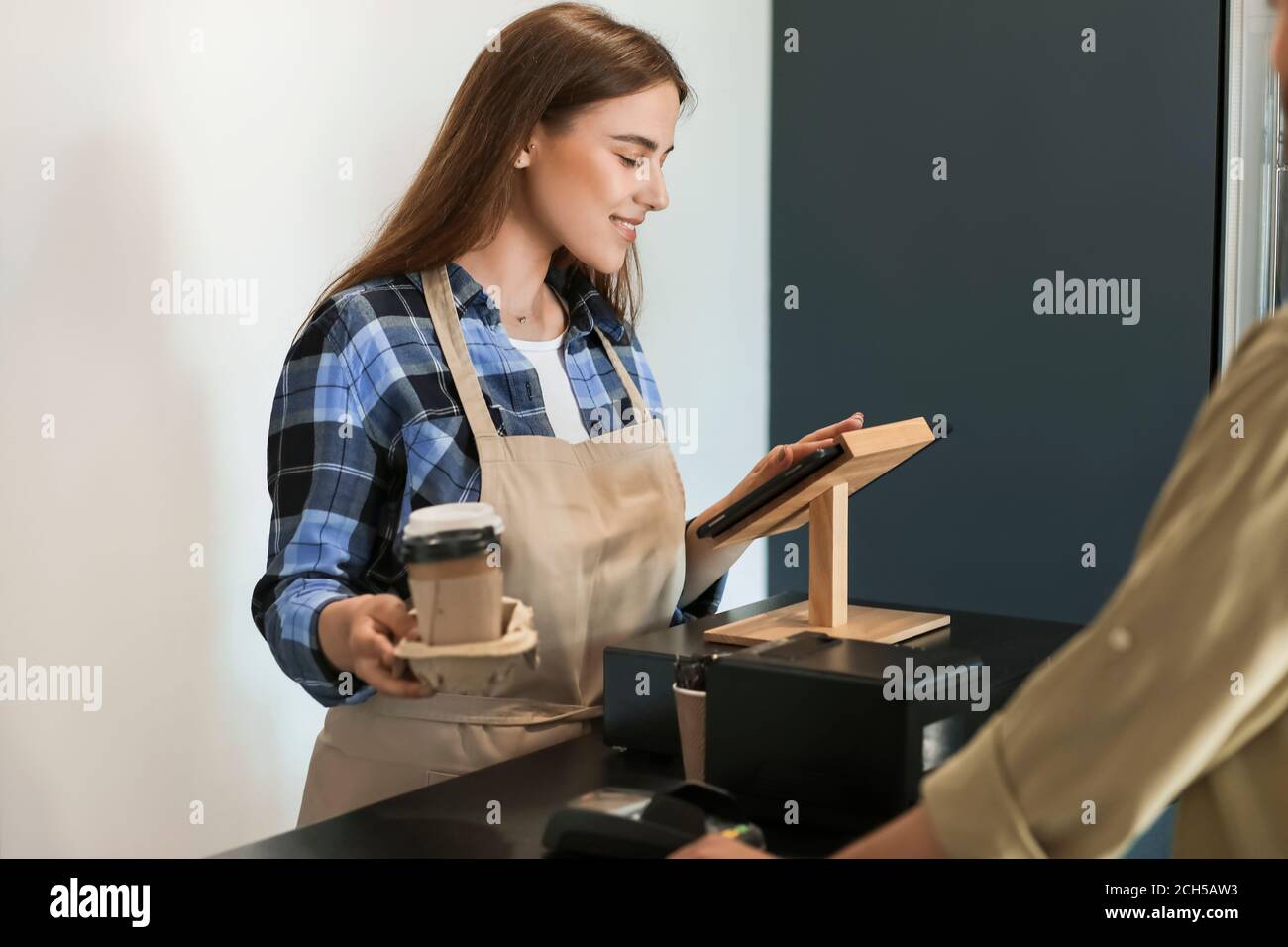 Female barista with client in modern cafe Stock Photo - Alamy