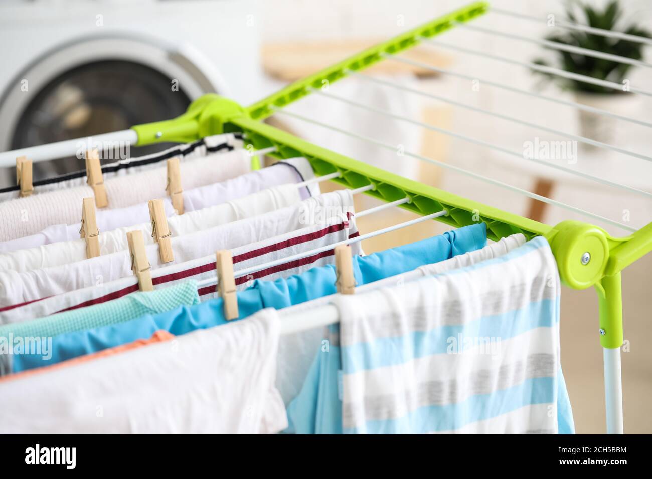 Clean clothes hanging on dryer in laundry room, closeup Stock Photo - Alamy