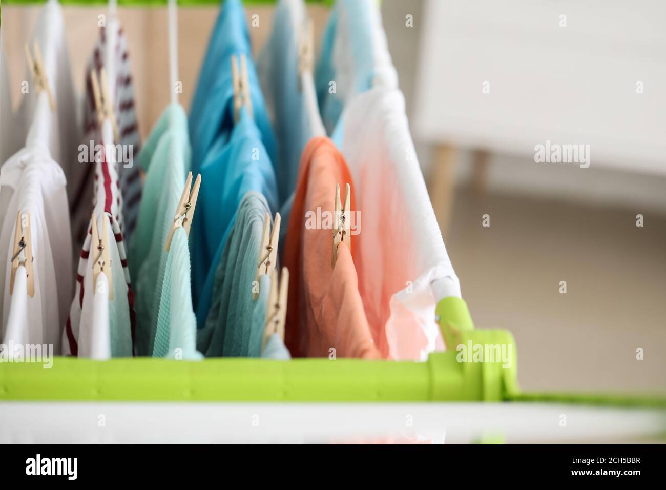 Clean clothes hanging on dryer in laundry room, closeup Stock Photo - Alamy