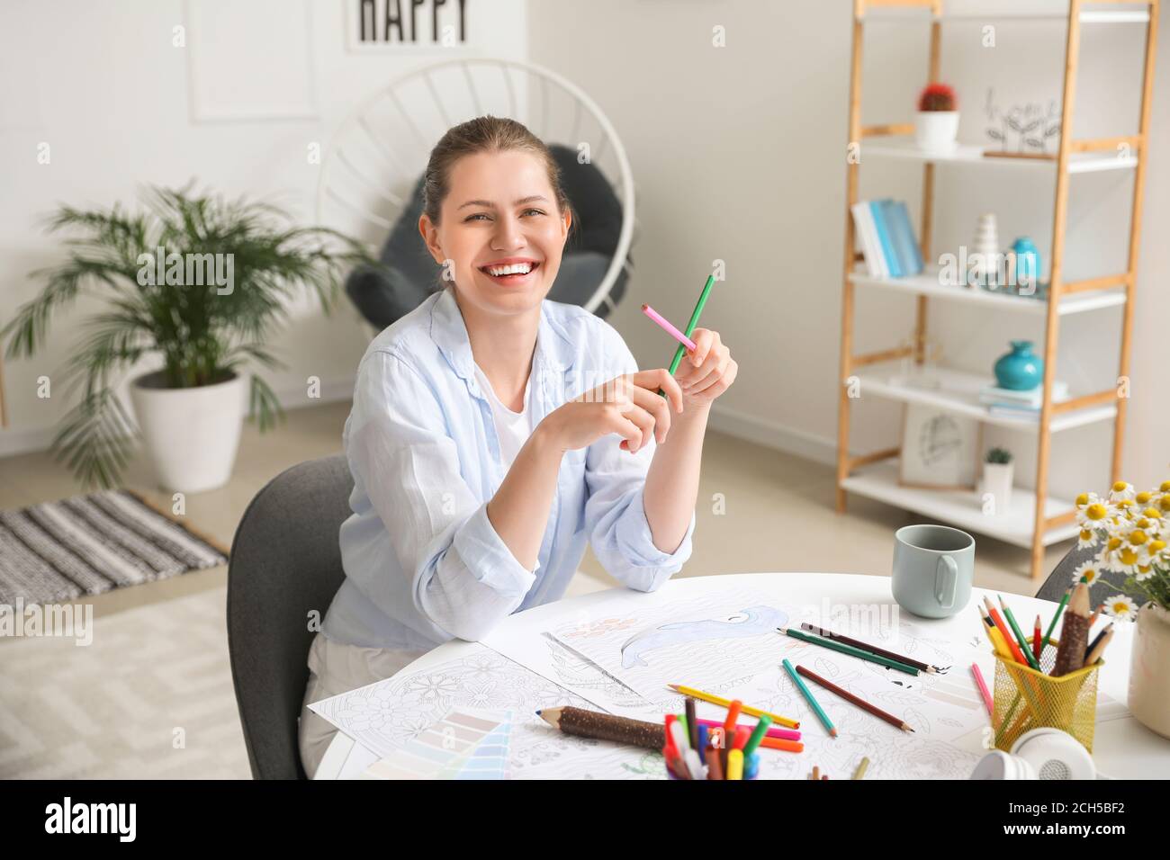 Young woman coloring picture at home Stock Photo - Alamy
