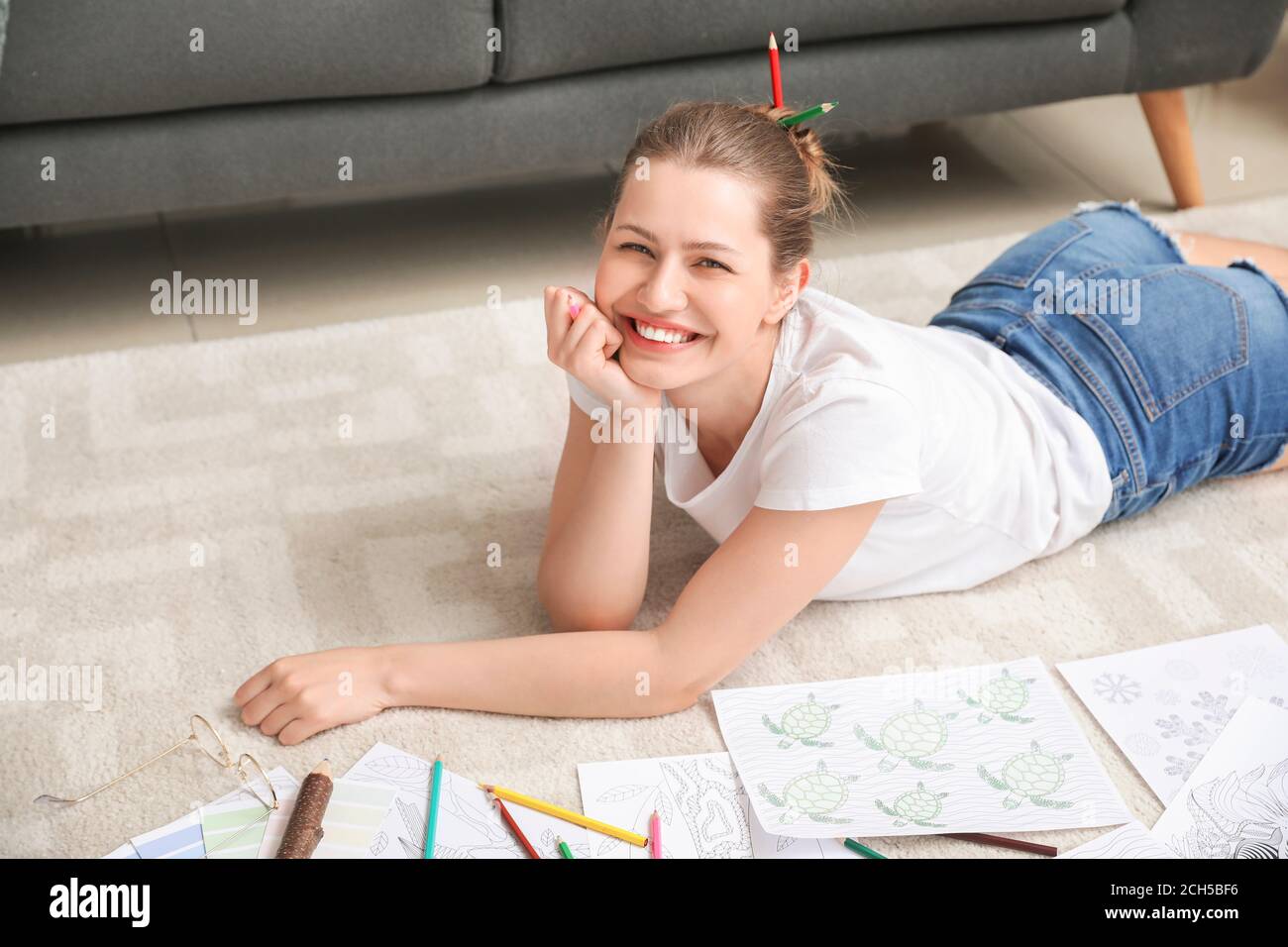 Young woman coloring picture at home Stock Photo - Alamy