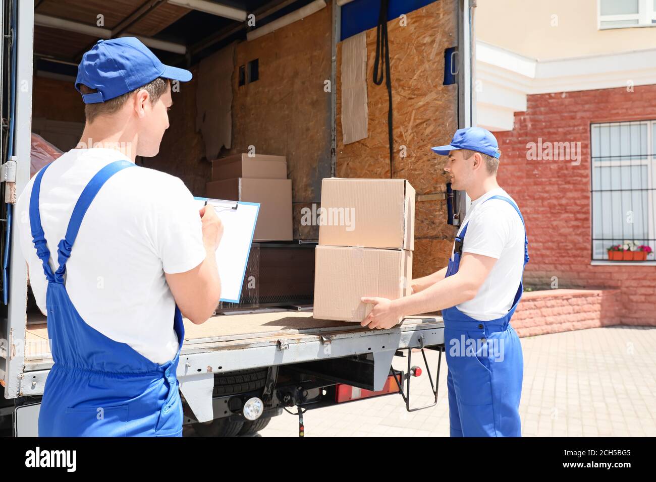 Loaders taking freight from truck Stock Photo - Alamy