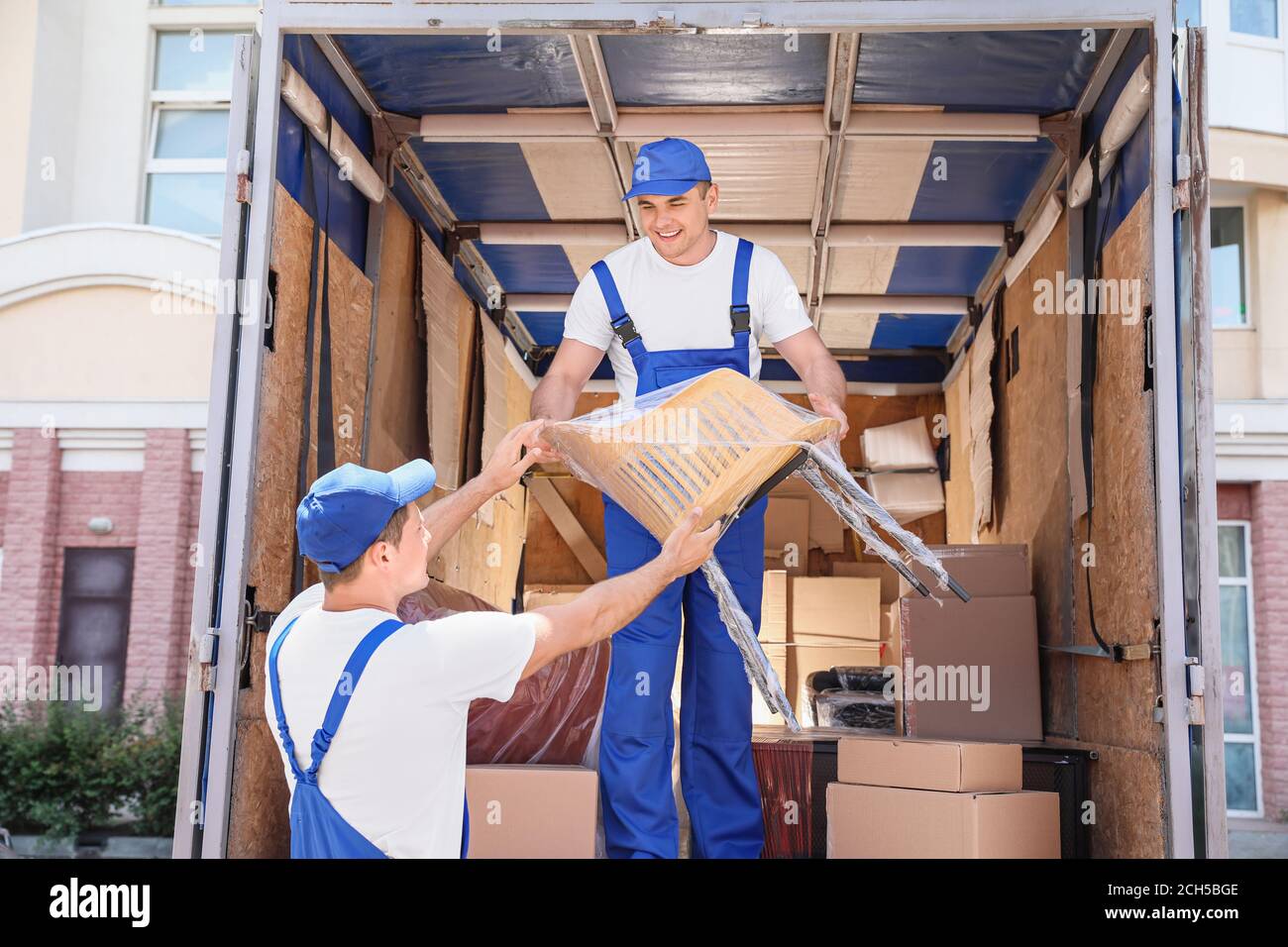 Loaders taking freight from truck Stock Photo - Alamy